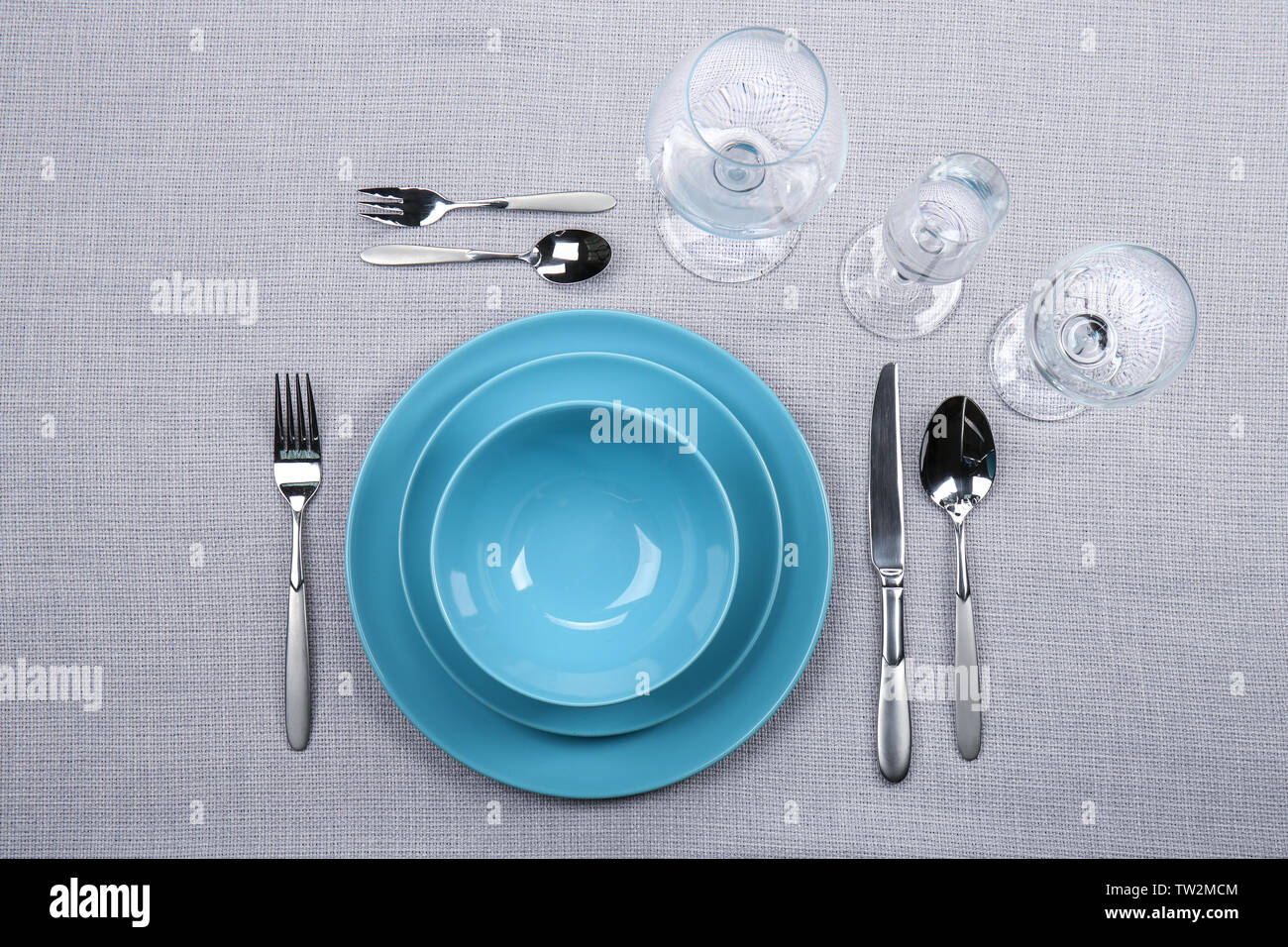 Table setting on light textile background Stock Photo - Alamy