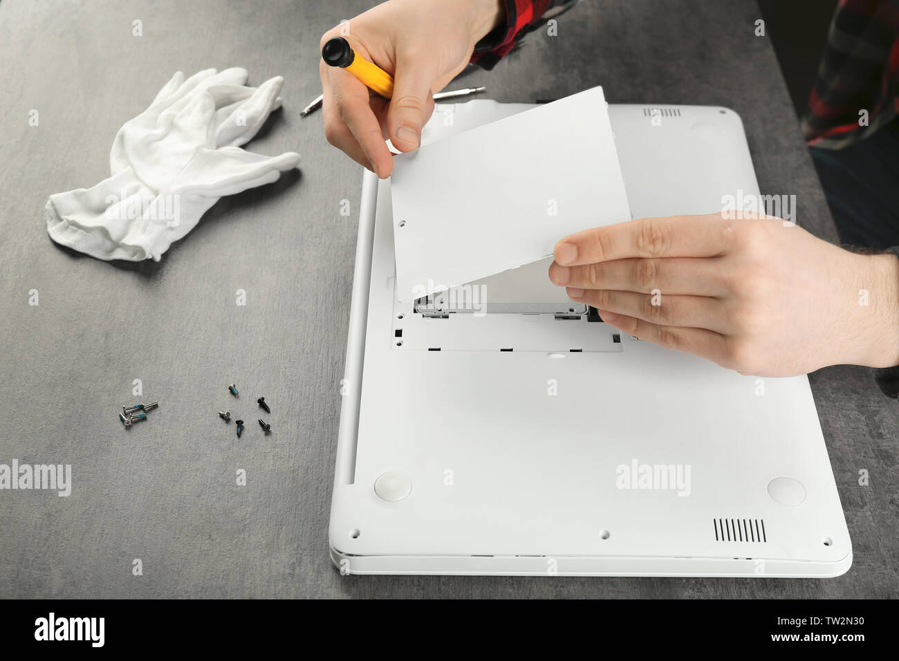 Male hands assembling laptop body on table. Concept of computer repair ...