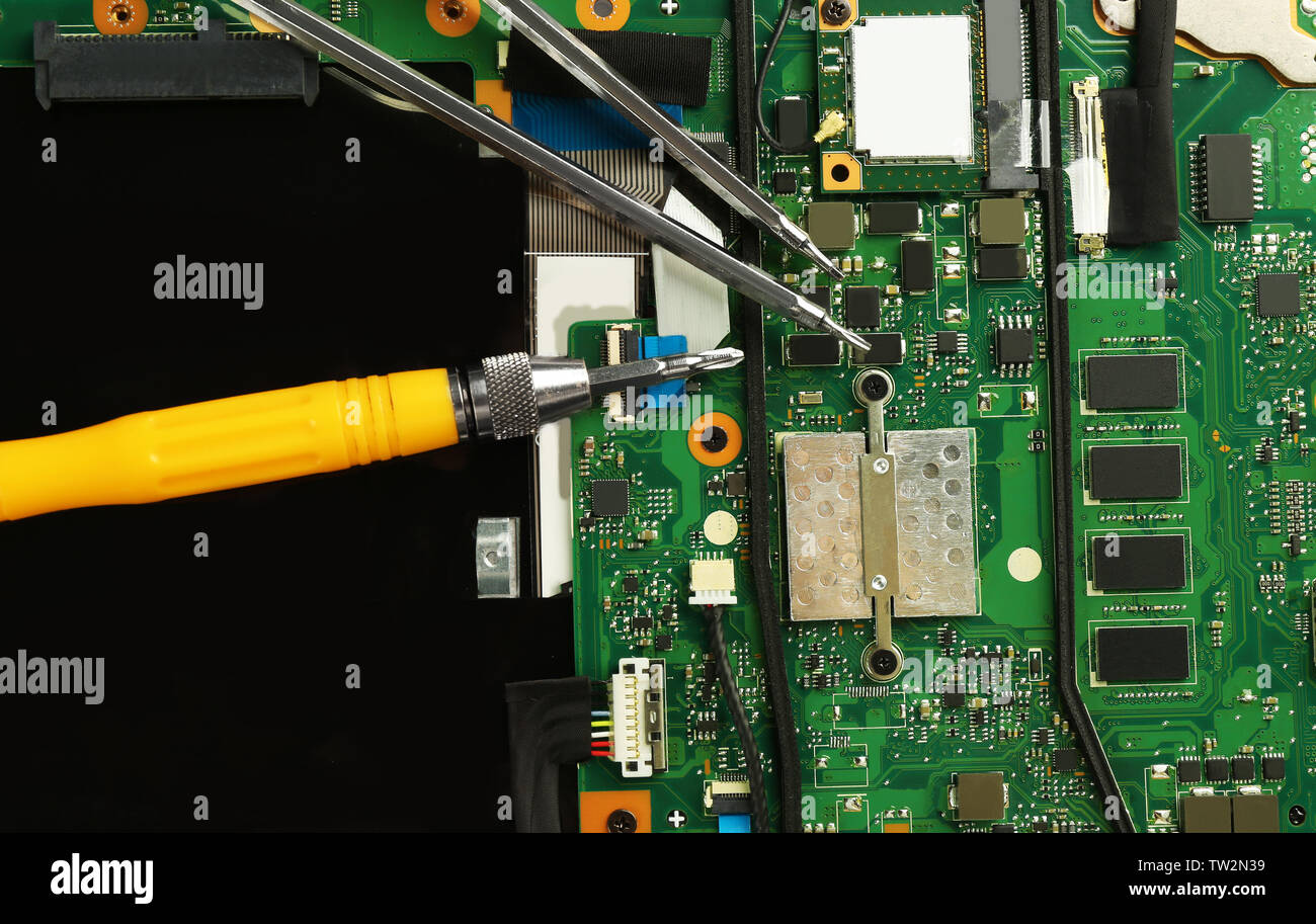 Motherboard in dismantled laptop and screwdriver, closeup. Concept of ...