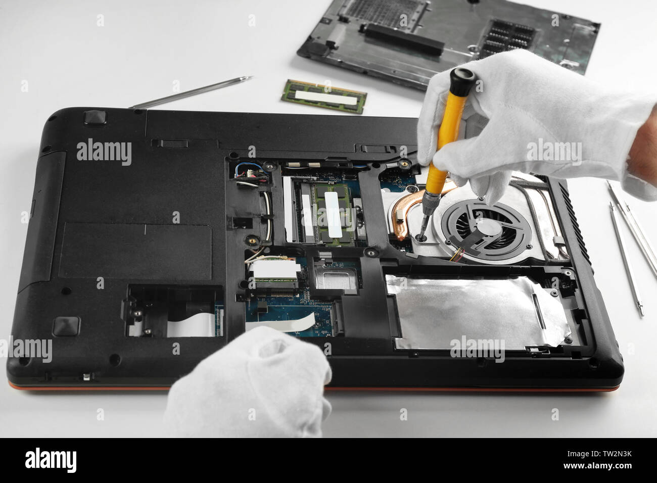 Dismantling laptop with screwdriver on white background. Concept of ...