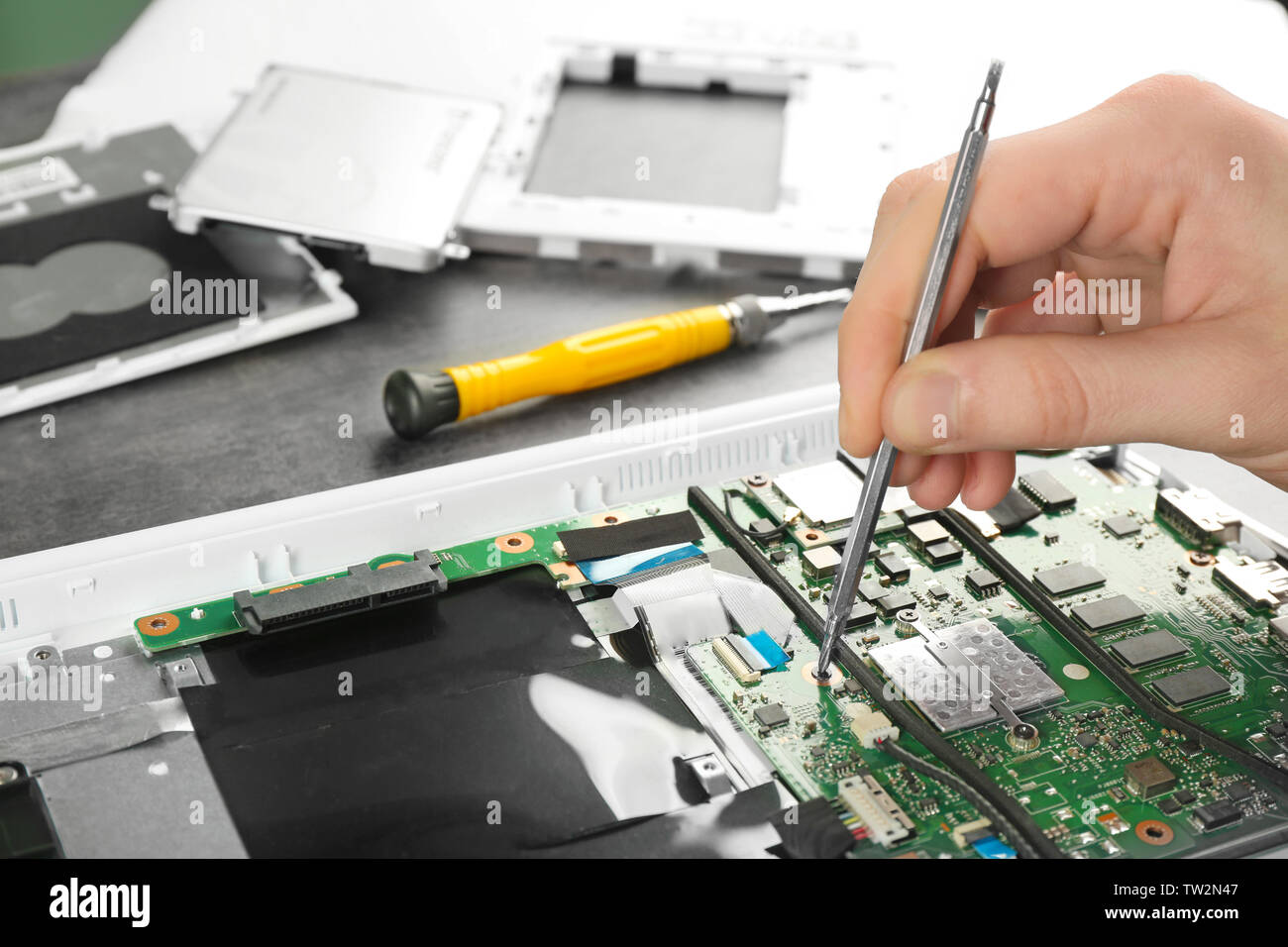 Man fixing dismantled laptop on table. Concept of computer repair Stock ...