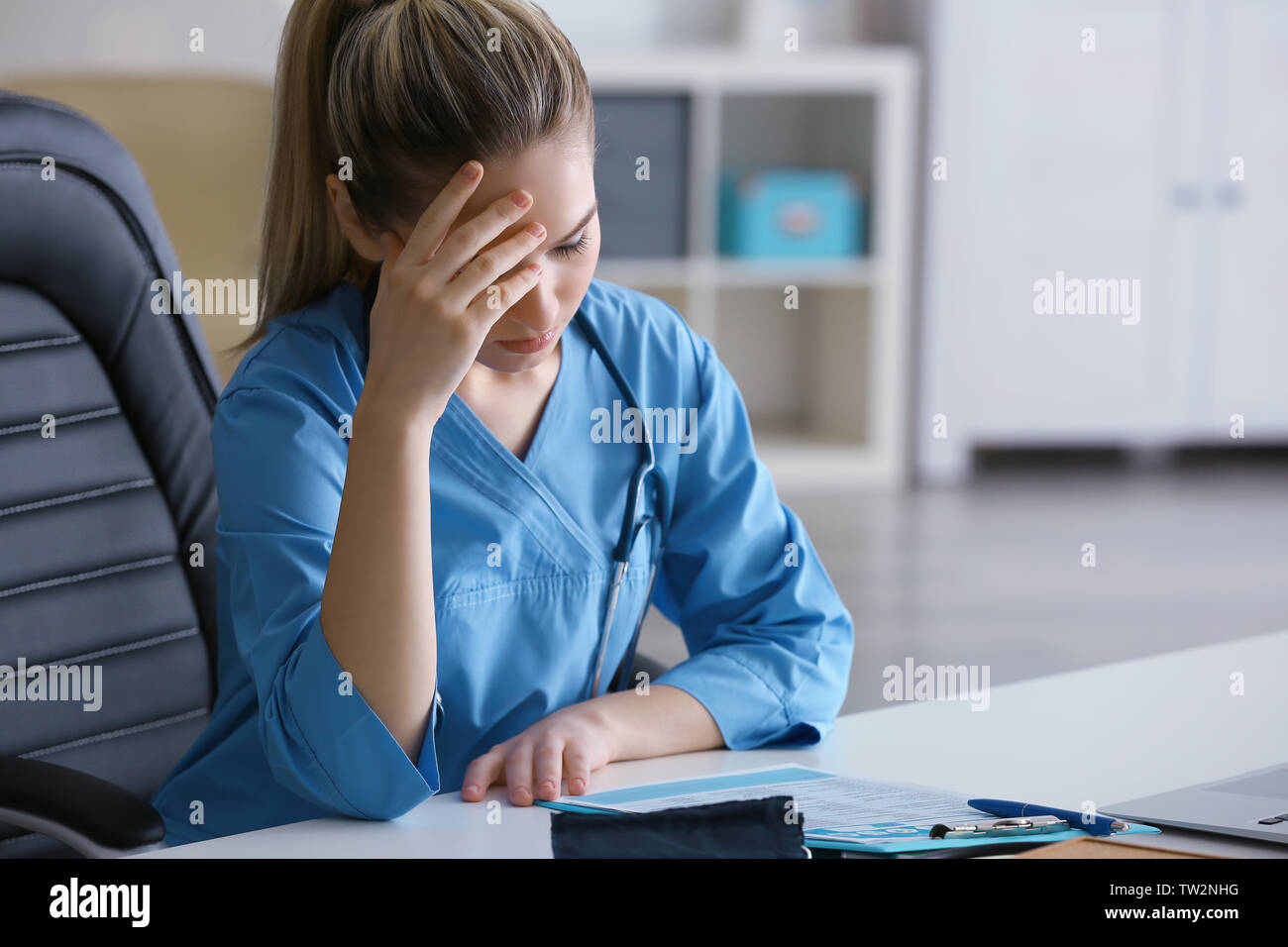 Tired medical assistant in her office Stock Photo - Alamy