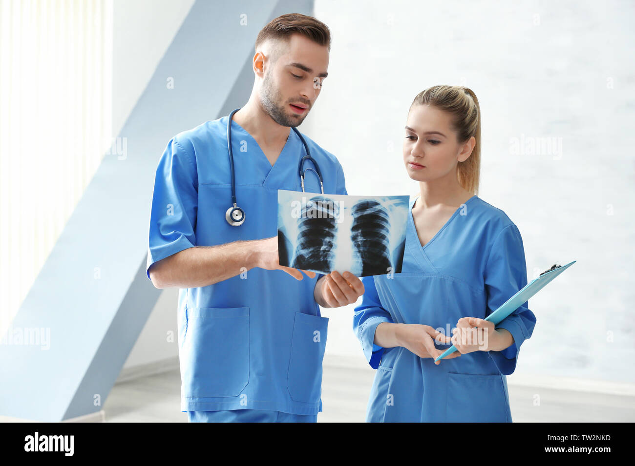 Doctor and medical assistant discussing x-ray image in office Stock ...