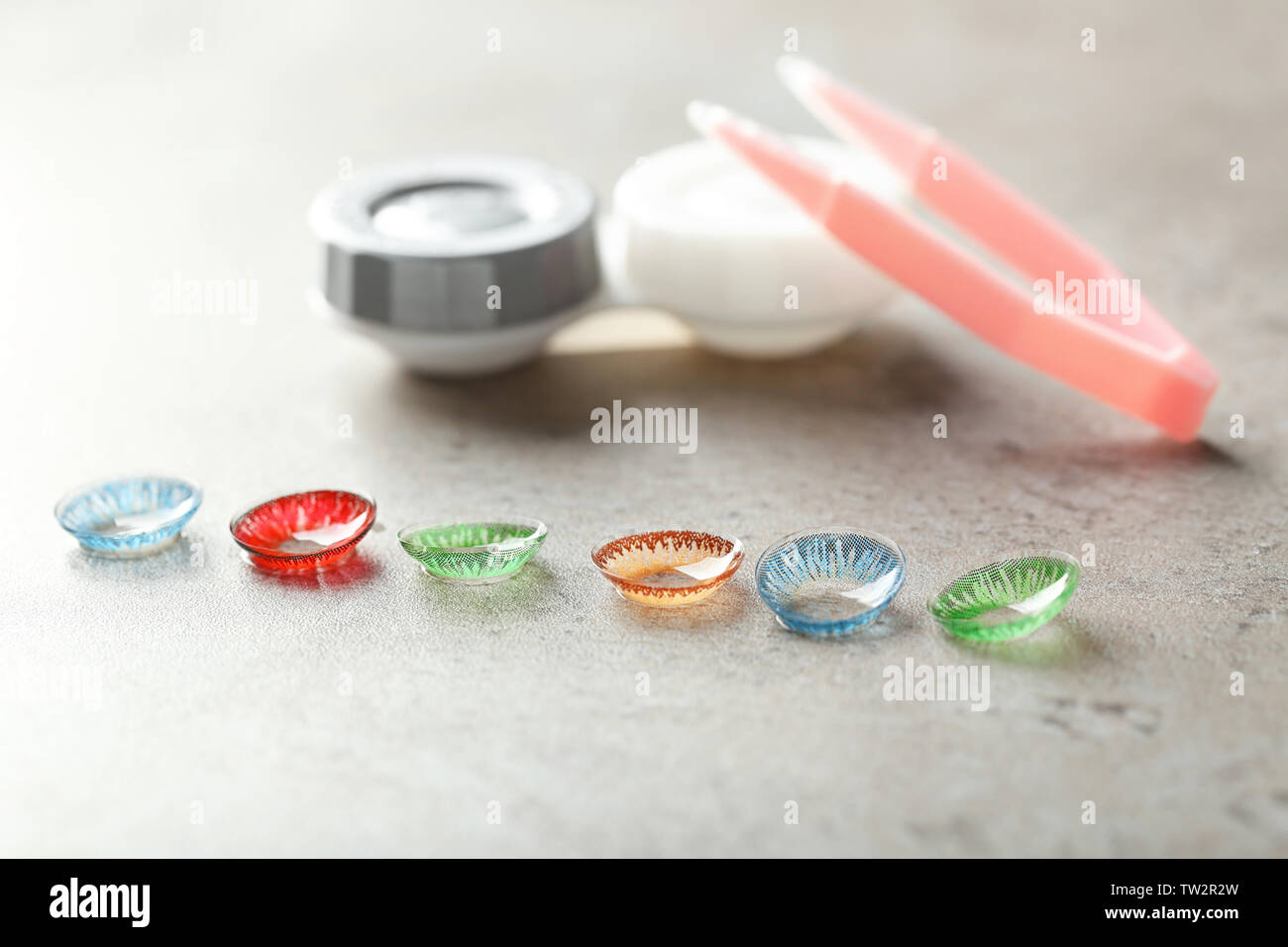 Different contact lenses on gray table Stock Photo - Alamy