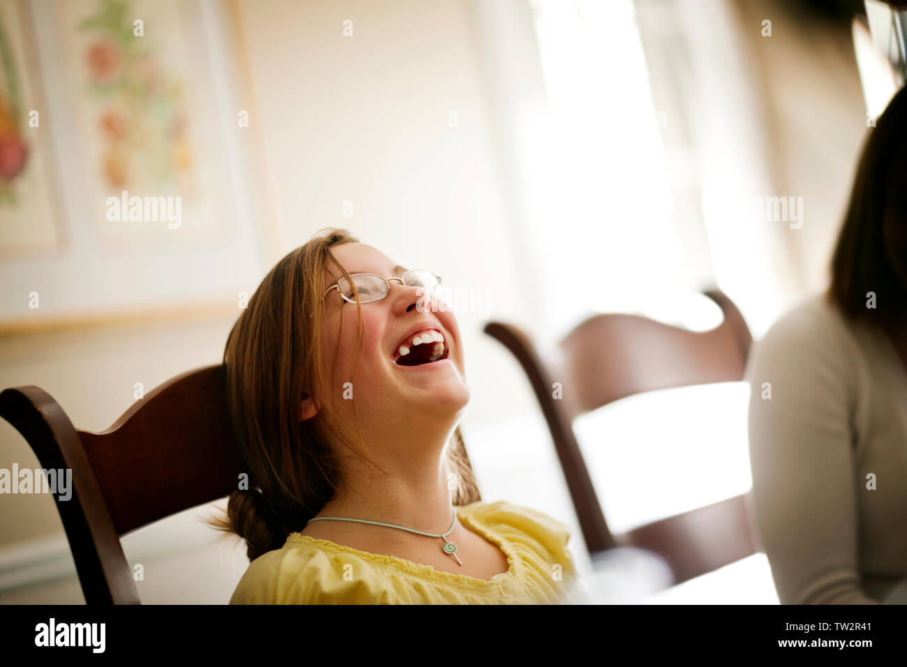 Girl laughing at dinner table Stock Photo - Alamy