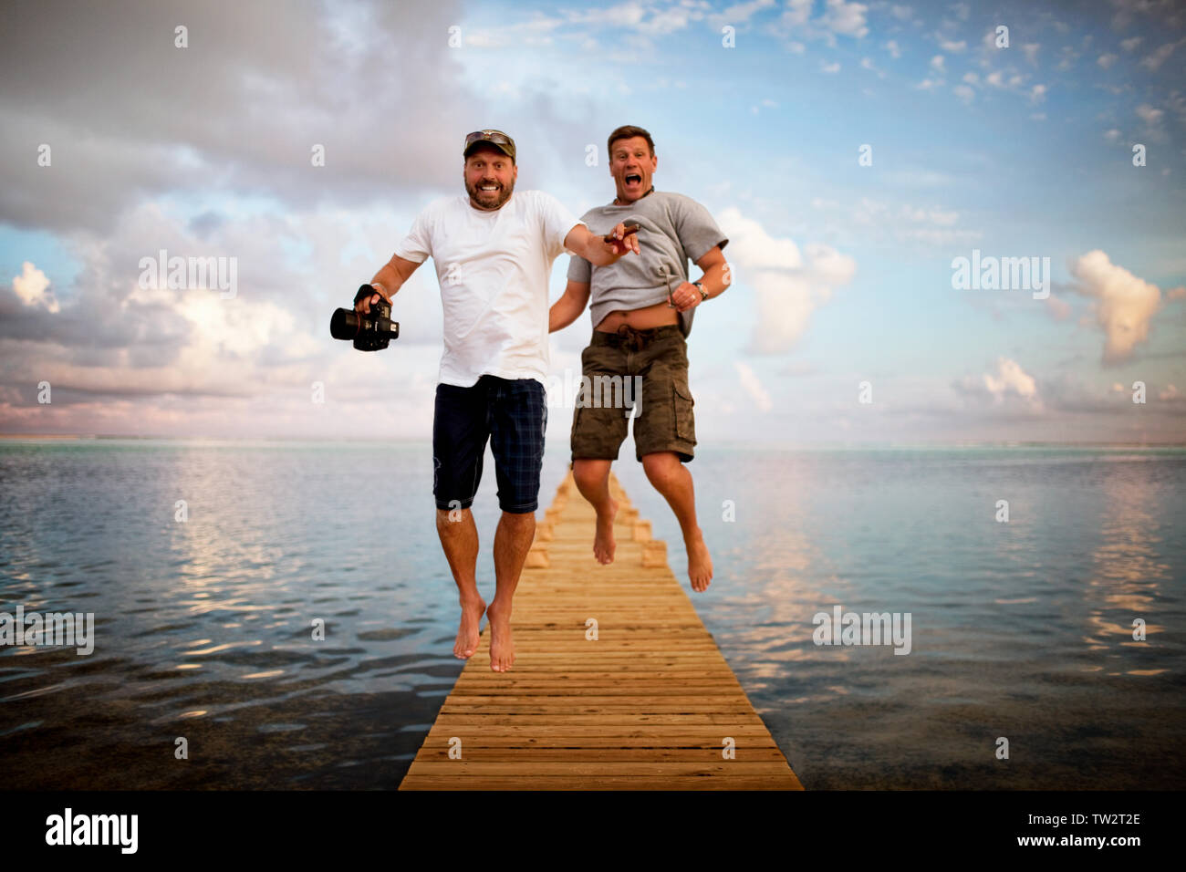 Men jumping for joy on a pier Stock Photo - Alamy