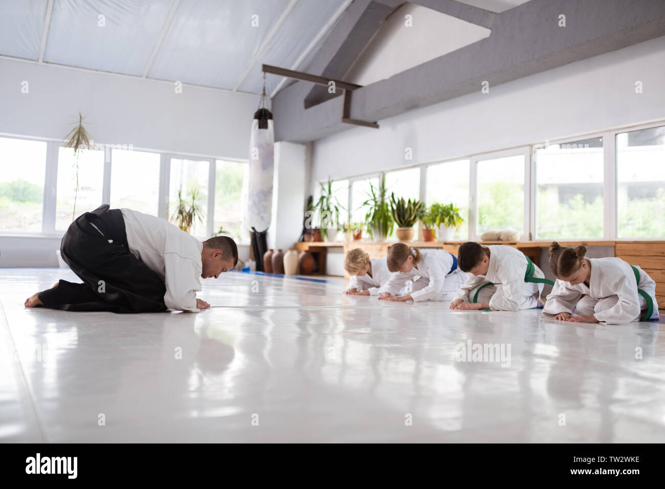 Before training. Trainer and children wearing white kimono greeting ...
