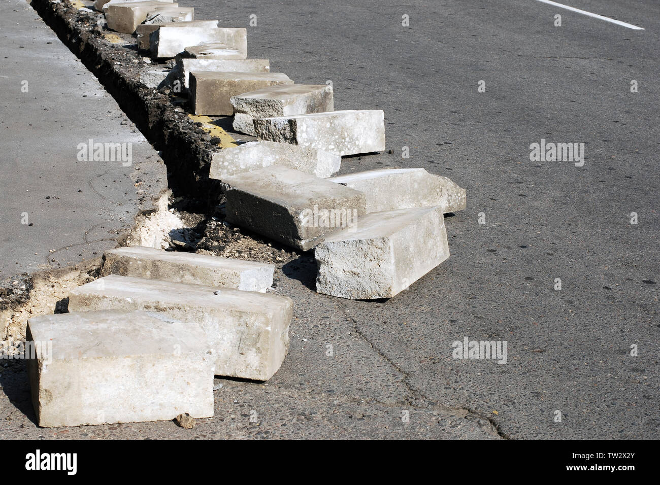 Repairing concrete curb on asphalt road, cracked split pieces of ...