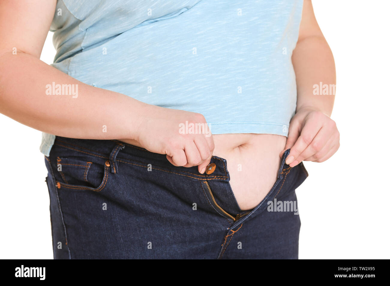 Stout adult woman trying to put on tight jeans against white background ...