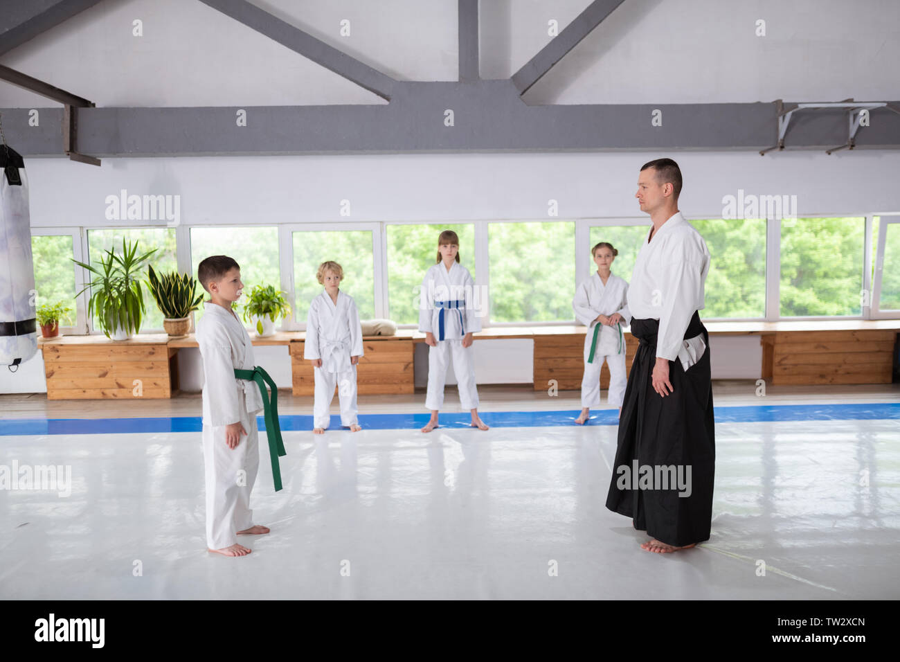 Boy and trainer. Little boy wearing white kimono standing in front of ...