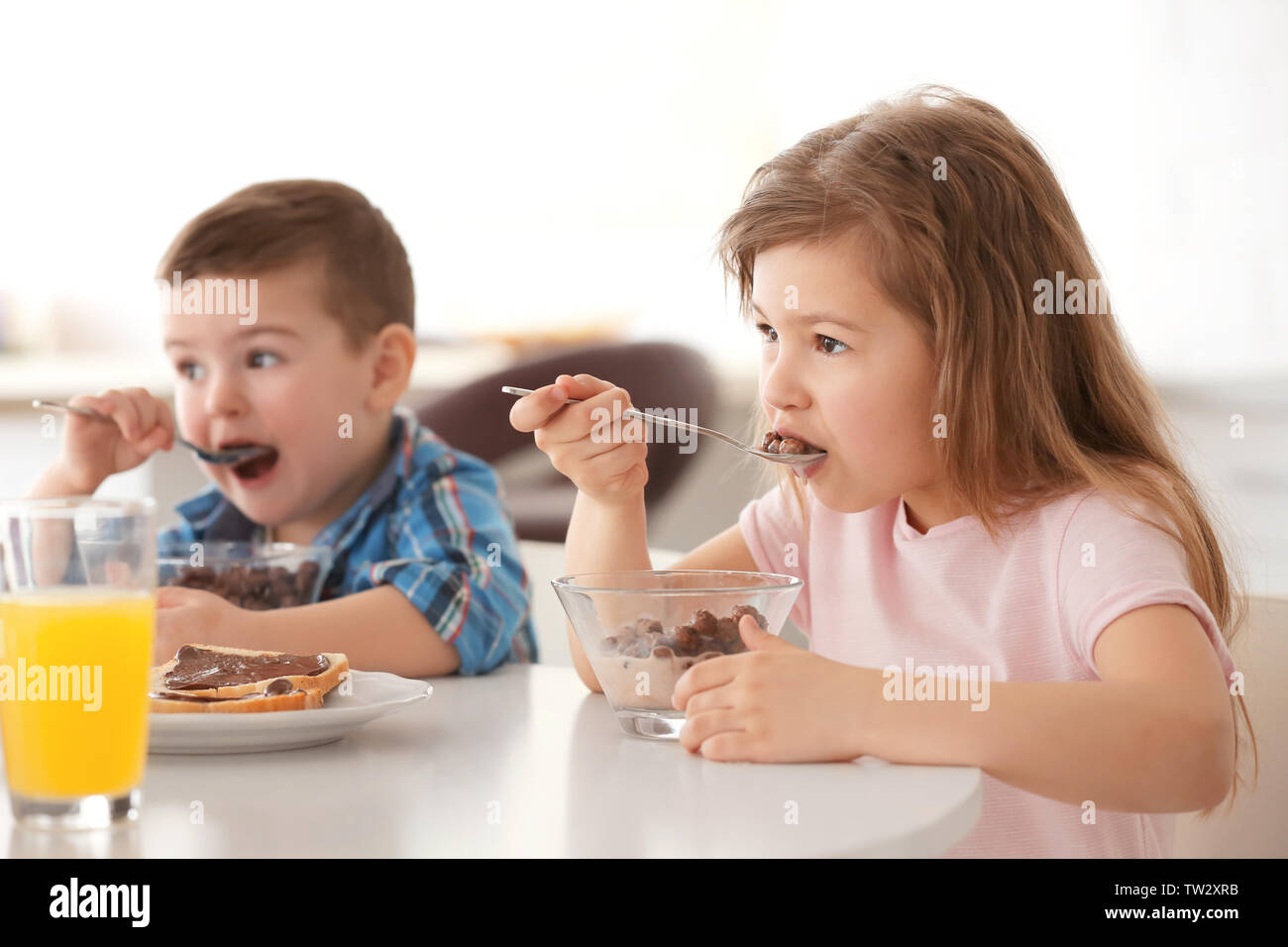 Cute little children having breakfast at home Stock Photo - Alamy