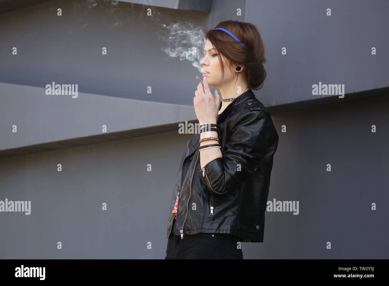 Beautiful young woman smoking weed outdoors Stock Photo - Alamy