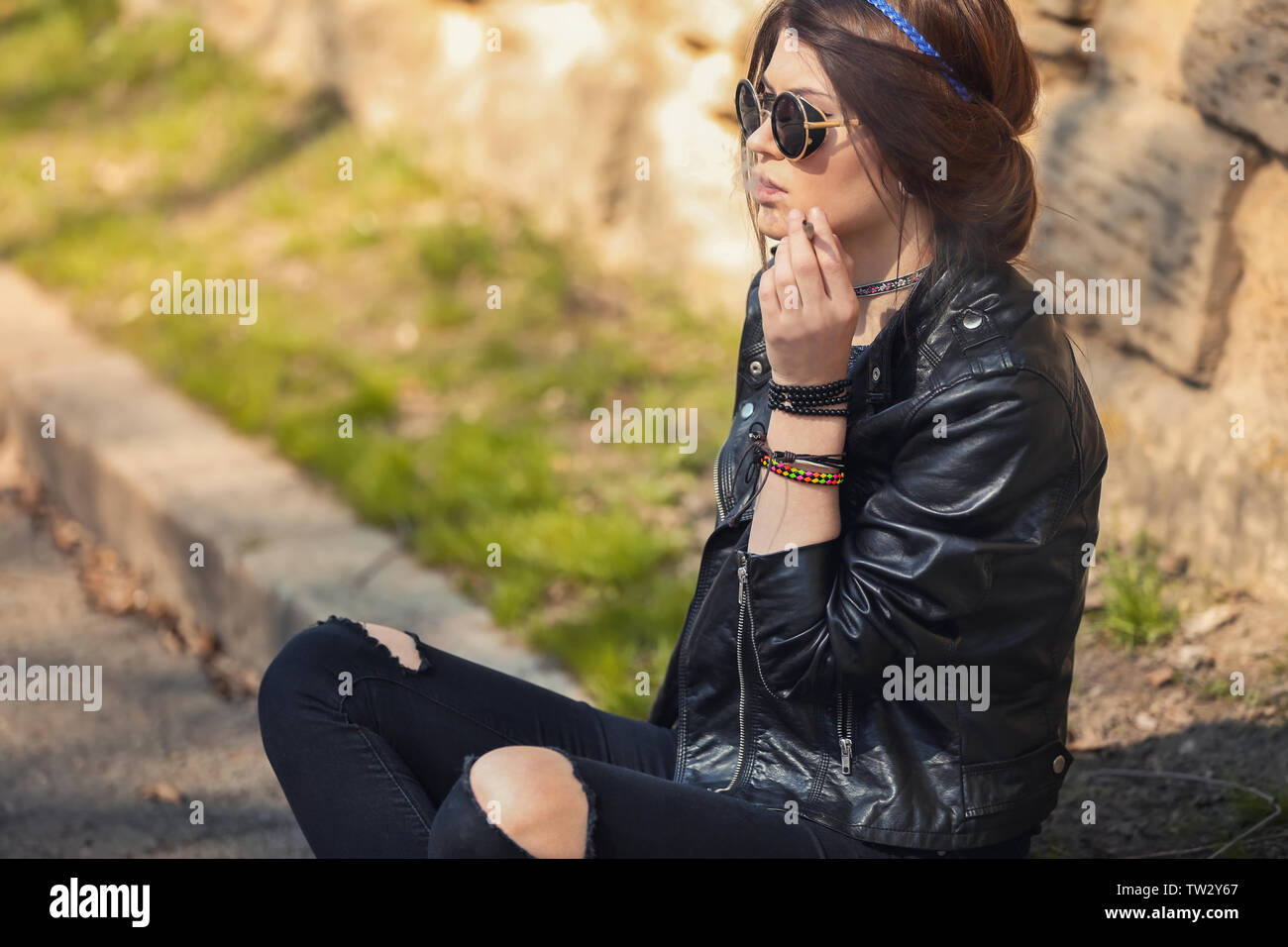 Beautiful young woman smoking weed outdoors Stock Photo - Alamy