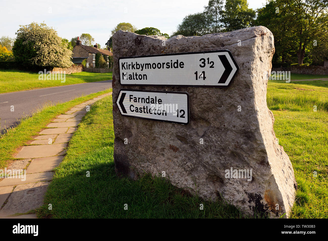 Direction signposts attached to rock in Hutton-le-Hole, North Yorkshire ...