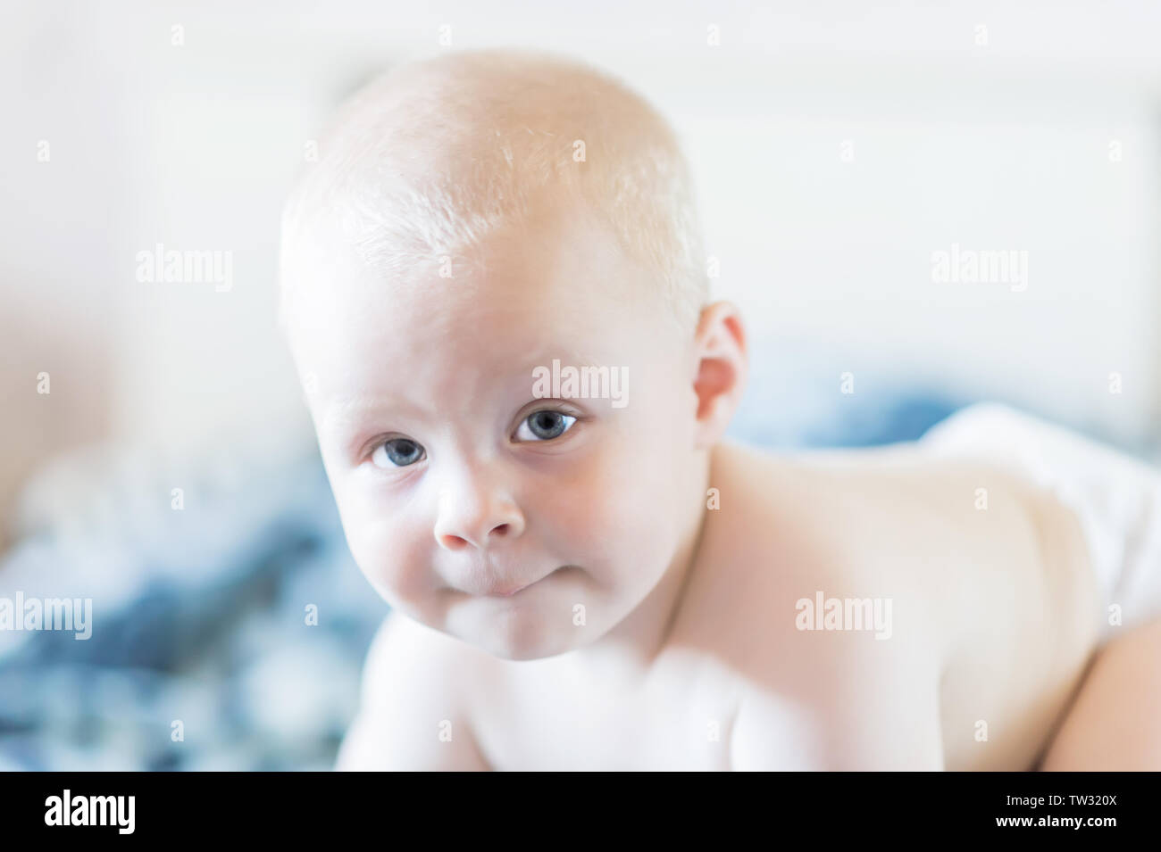 Little toddler boy playing on the bed. Palyful and mischievous eyes ...