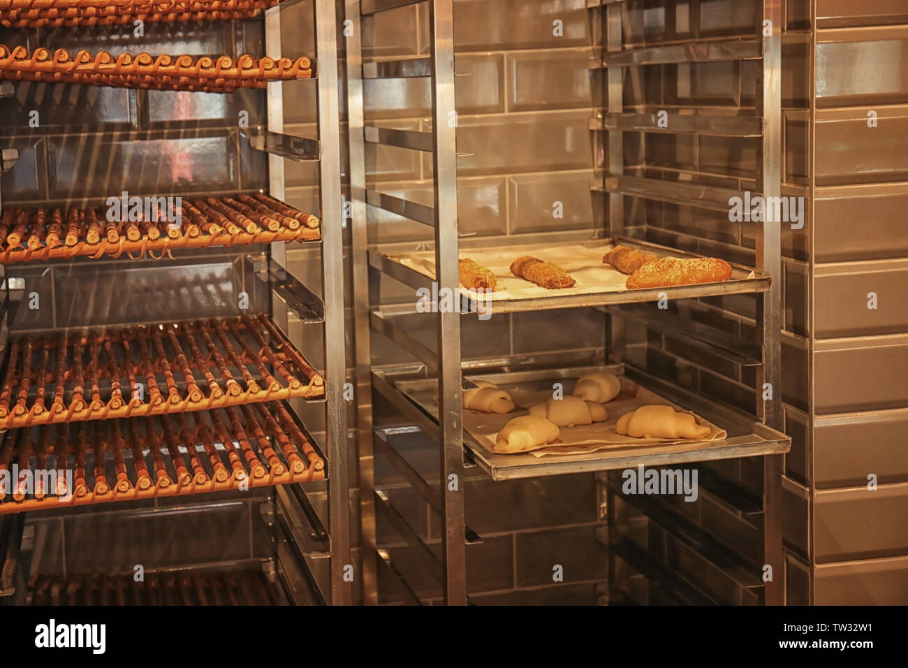 Rack with pastry on trays in bakery Stock Photo - Alamy