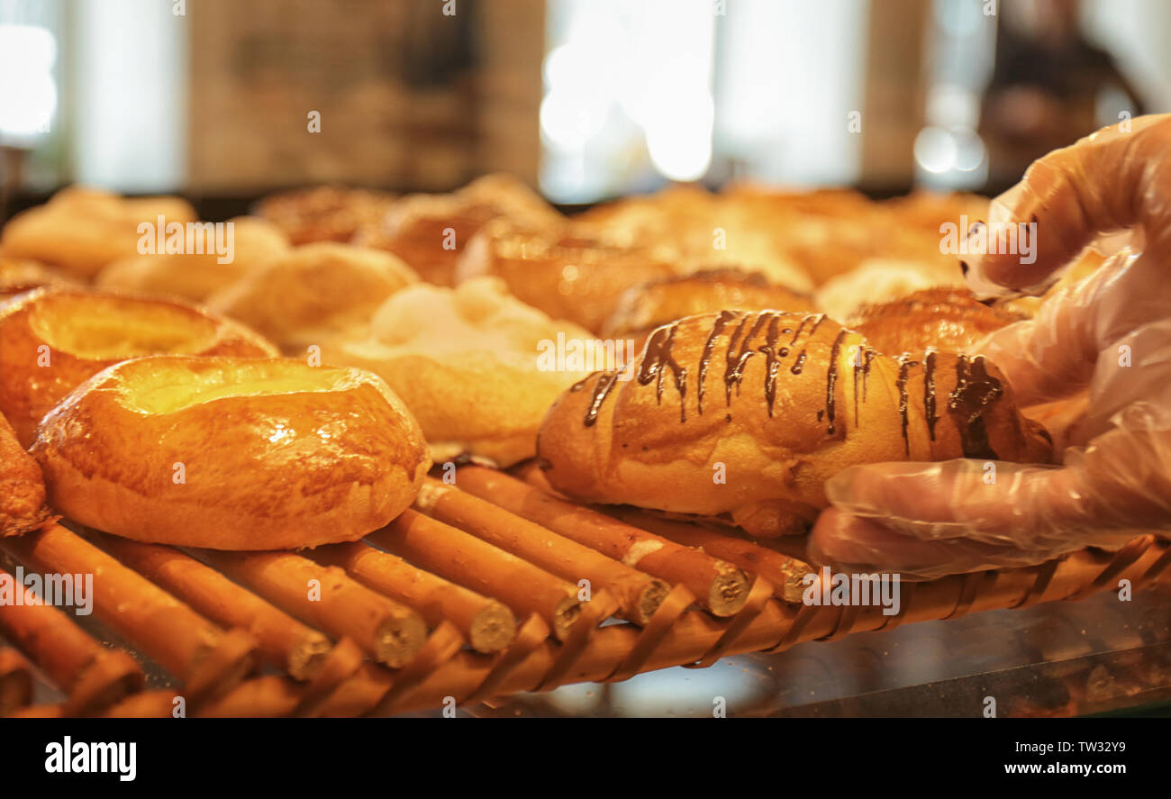 Female hand with pastry at counter in shop Stock Photo - Alamy