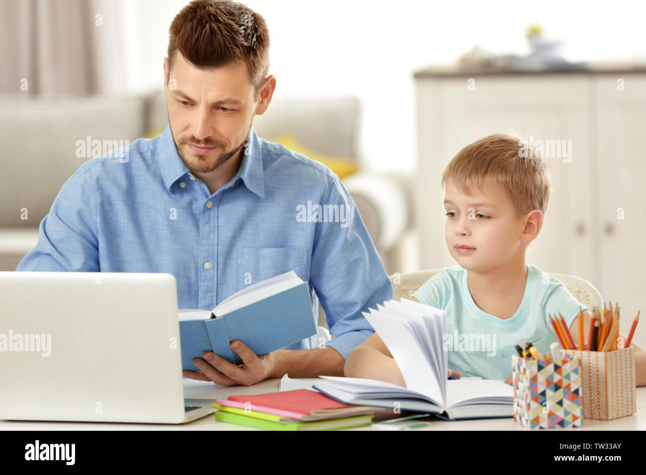 Father and son doing homework together at home Stock Photo - Alamy