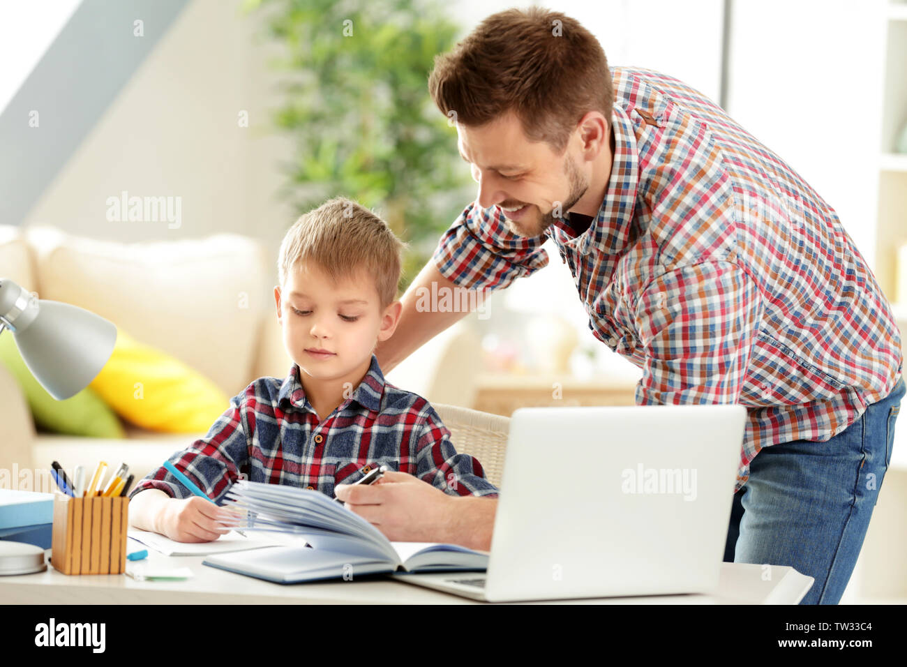 Father and son doing homework together at home Stock Photo - Alamy