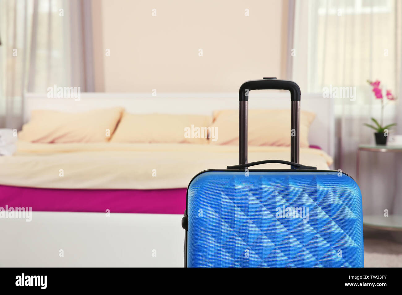 Blue suitcase in light hotel room Stock Photo - Alamy