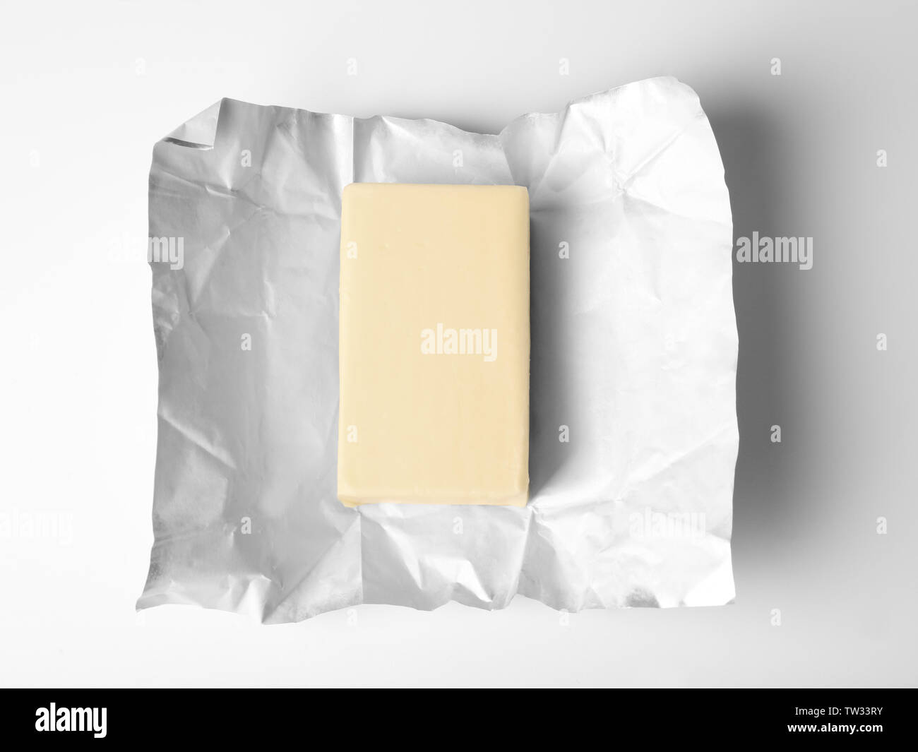 Wrapping with piece of butter on white background Stock Photo - Alamy
