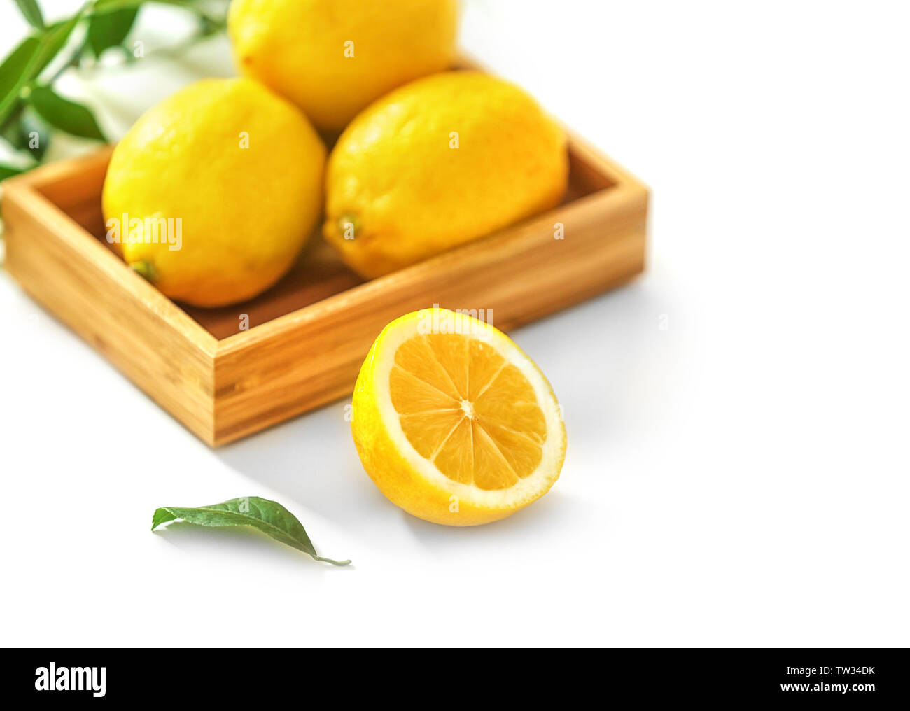 Wooden box with lemons on white background Stock Photo - Alamy