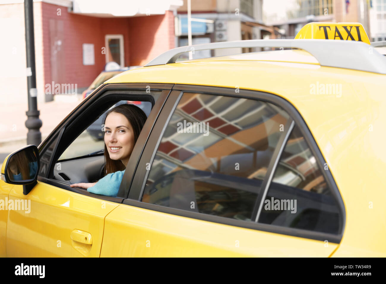 Female taxi driver sitting in yellow car Stock Photo - Alamy