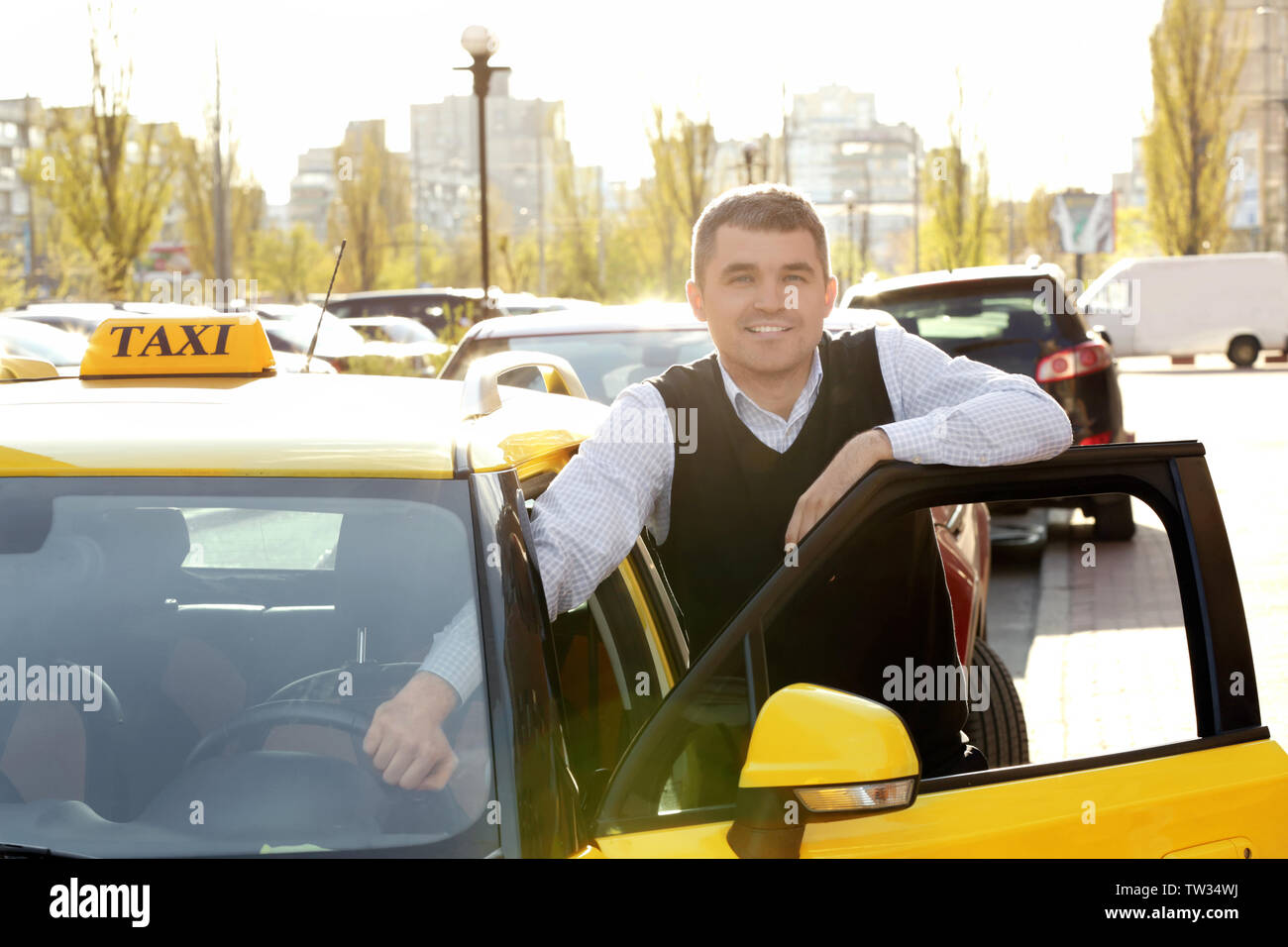 Handsome taxi driver standing near car with opened door on street Stock ...