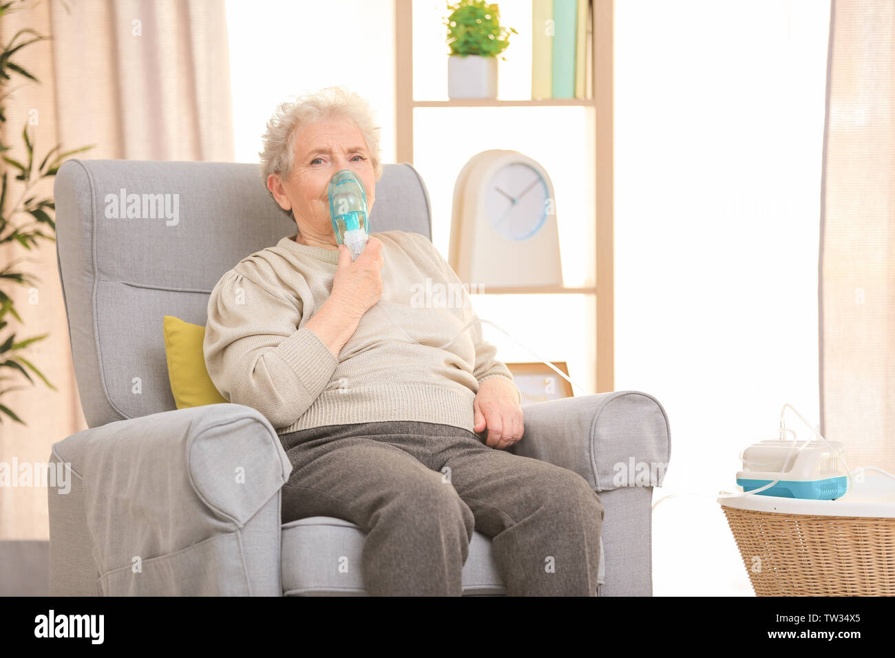 Elderly woman using asthma machine at home Stock Photo - Alamy