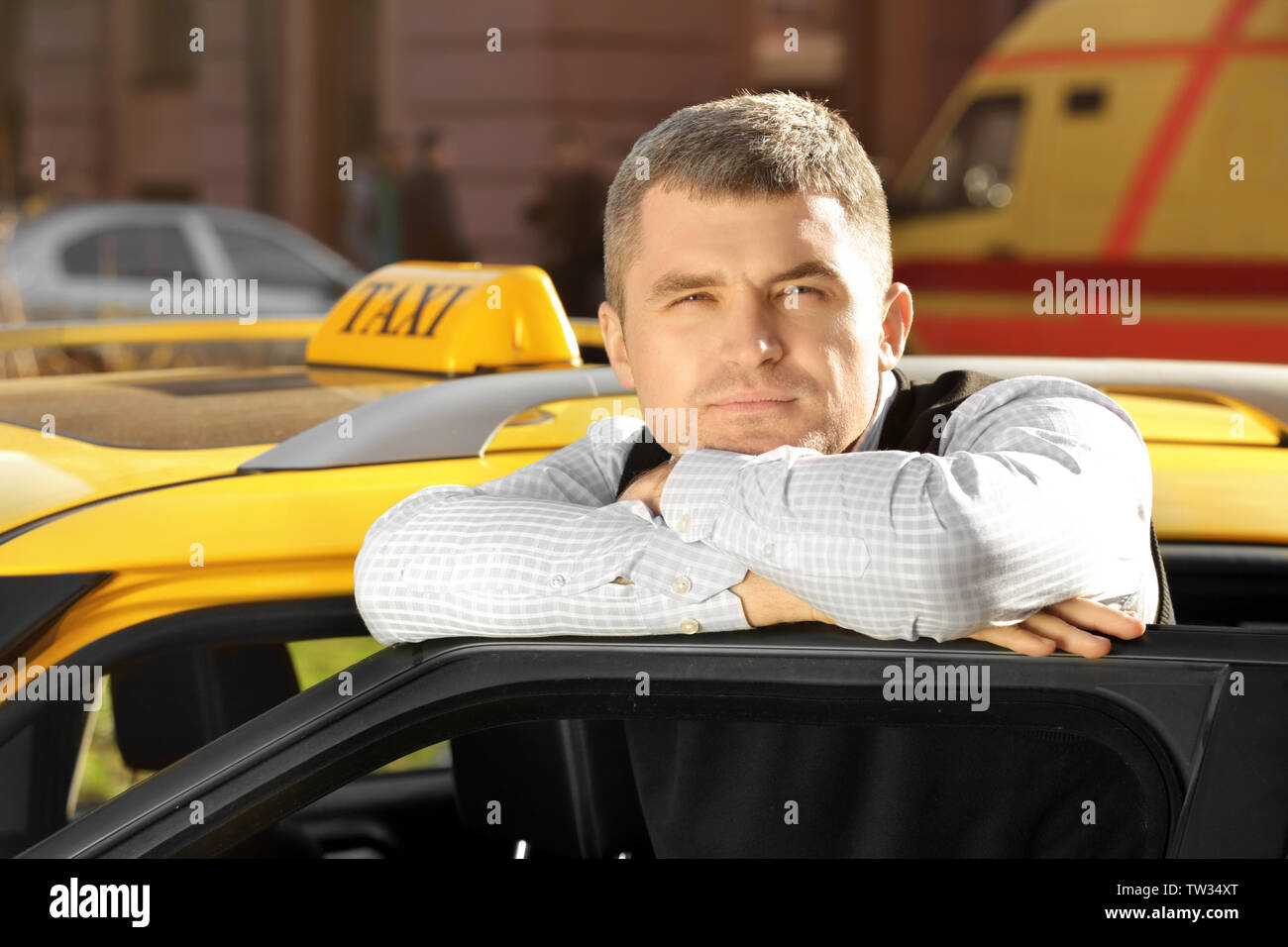 Handsome taxi driver standing near car with opened door on street Stock ...