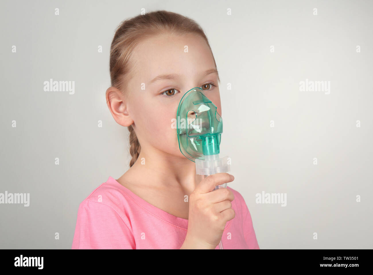 Girl using asthma machine on light background Stock Photo - Alamy