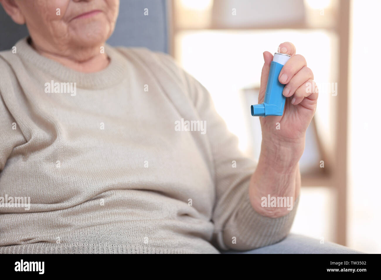 Elderly woman with inhaler for asthma at home Stock Photo - Alamy