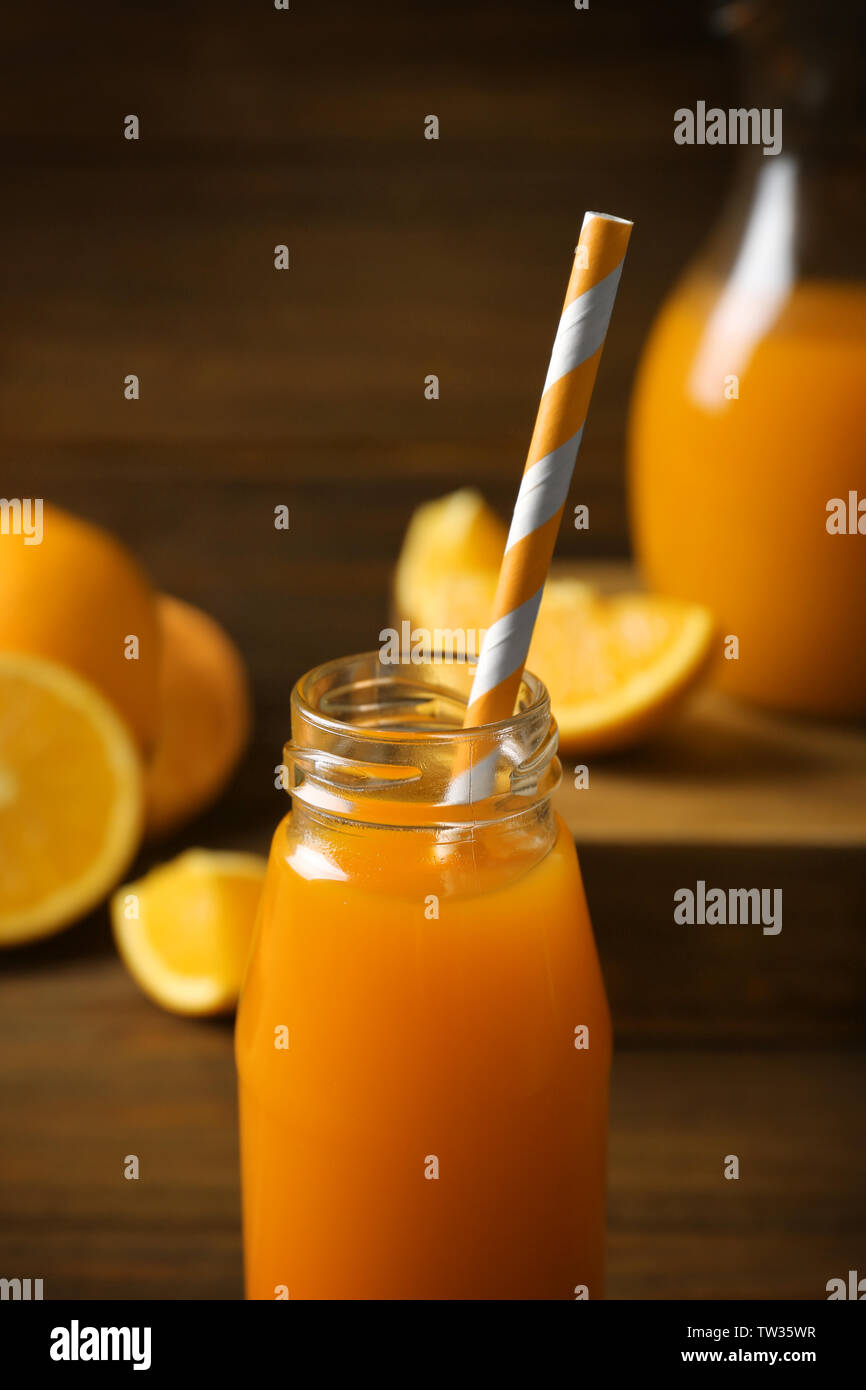 Delicious orange juice in bottle on blurred background Stock Photo - Alamy