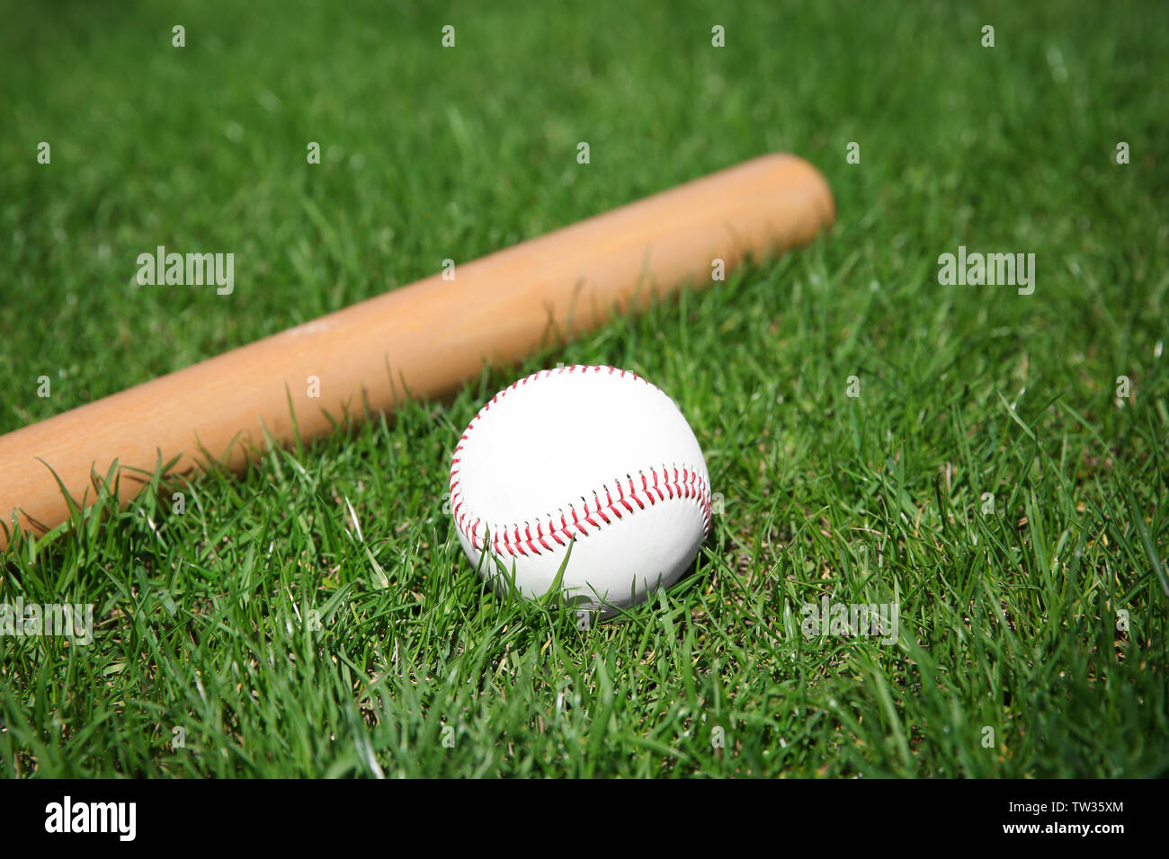 Baseball ball and bat on fresh green grass outdoors Stock Photo - Alamy