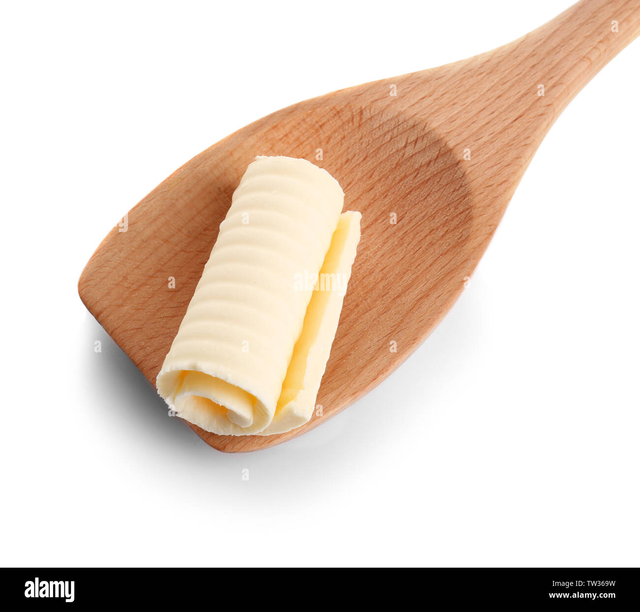 Delicious butter curl in wooden spoon on white background, closeup ...