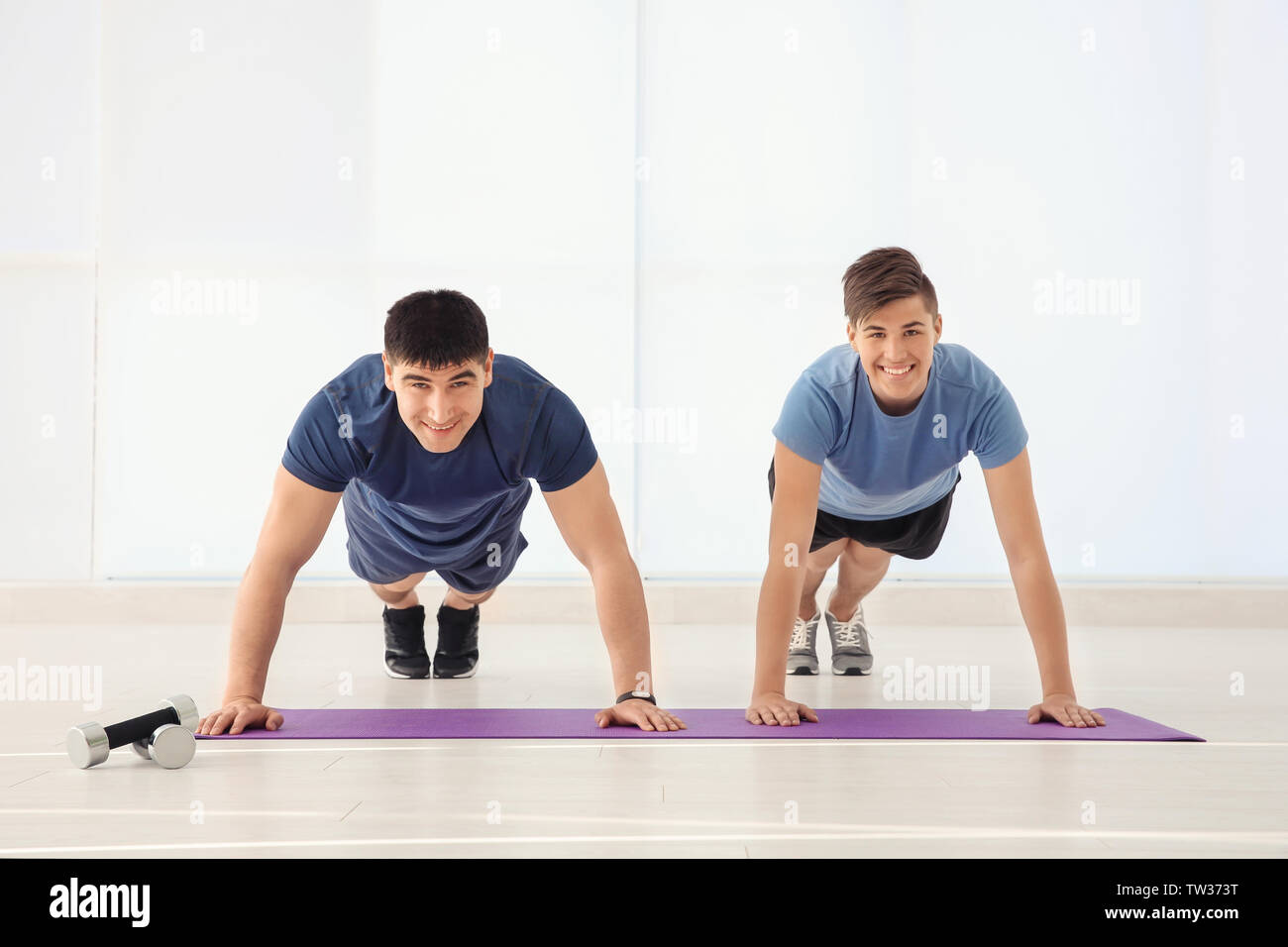 Dad and son training in gym Stock Photo - Alamy