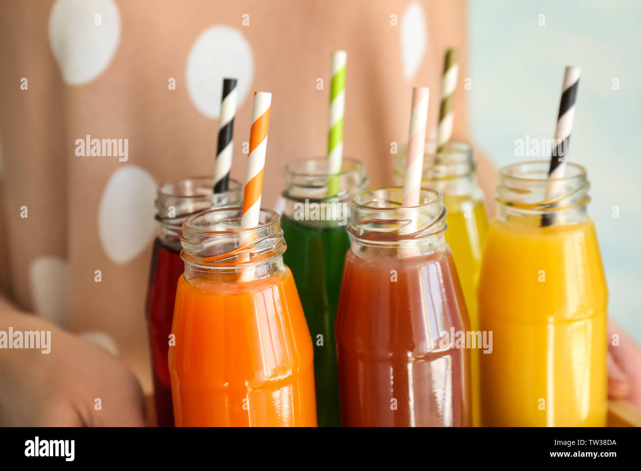 Young woman with delicious juices in bottles, closeup Stock Photo - Alamy