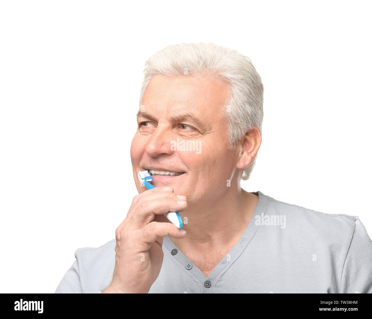 Senior man cleaning teeth on white background Stock Photo - Alamy