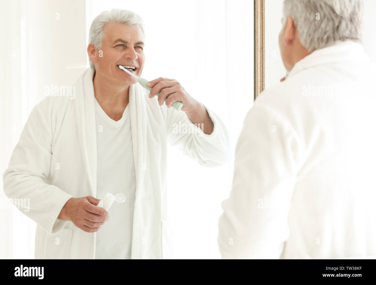 Senior man cleaning teeth at home Stock Photo - Alamy