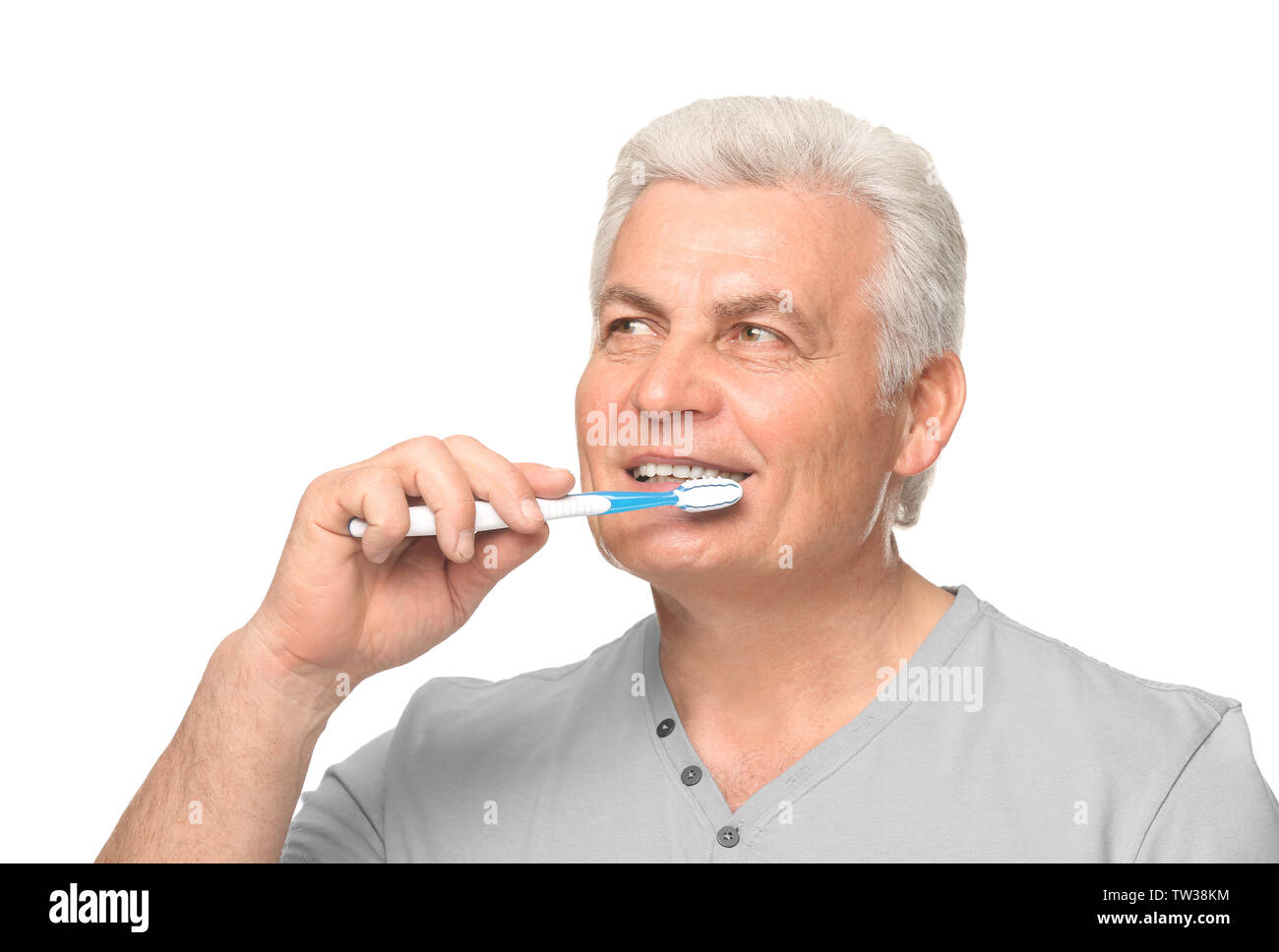 Senior man cleaning teeth on white background Stock Photo - Alamy