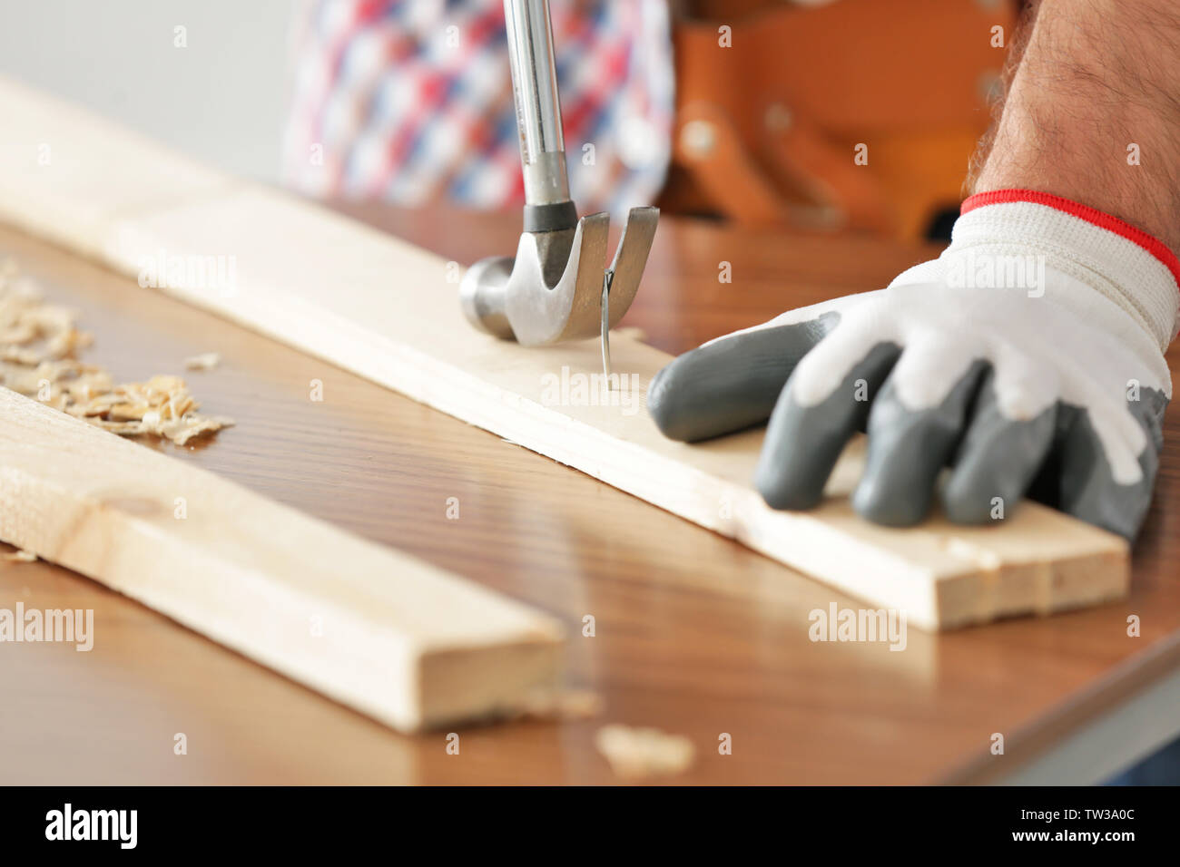 Carpenter pulling out nail from wooden plank, closeup Stock Photo - Alamy