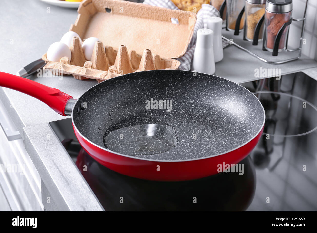 Frying pan with oil on black stove Stock Photo - Alamy