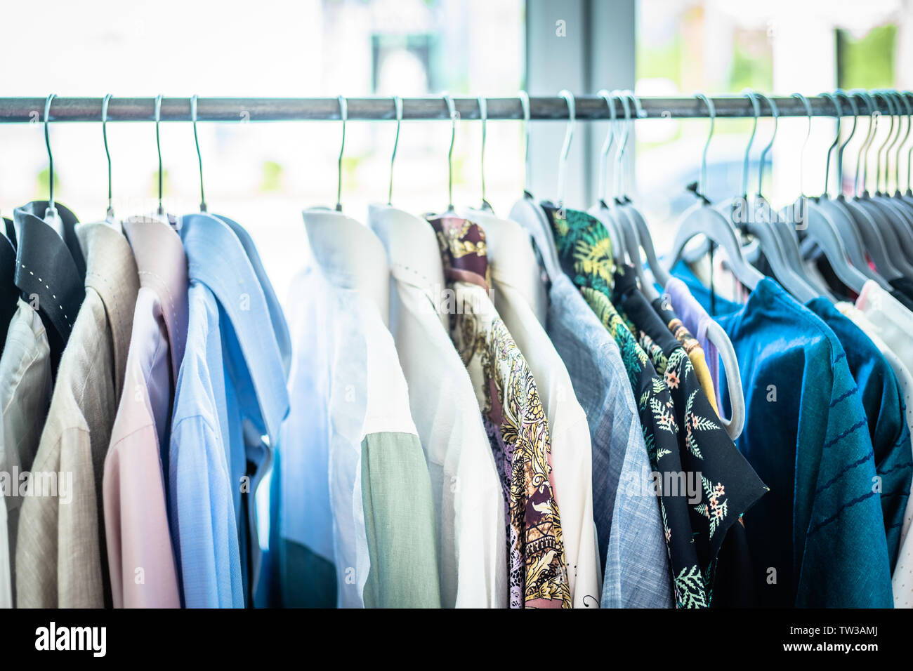 Summer wardrobe showcase. White and gray tone knitwear hanging on a ...