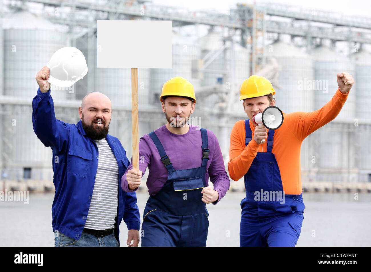 Group of protesting young men and factory on background Stock Photo - Alamy