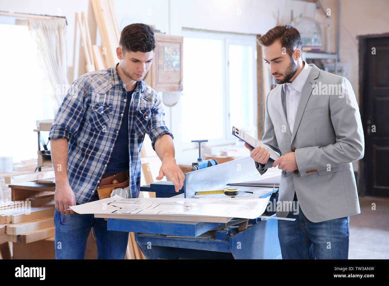 Young carpenter and customer in workshop Stock Photo - Alamy