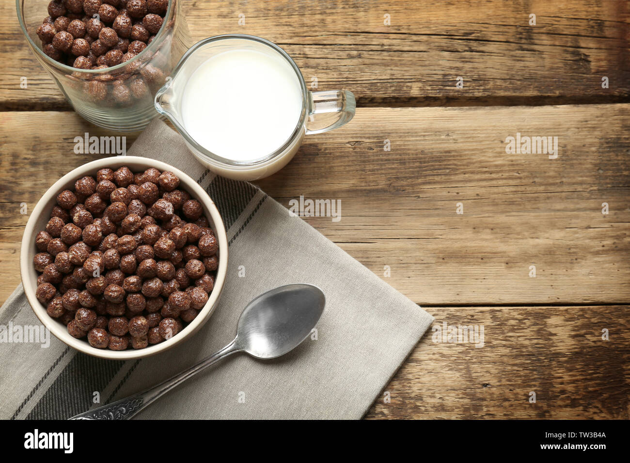 Chocolate corn balls in bowl and jug with milk on wooden table Stock ...