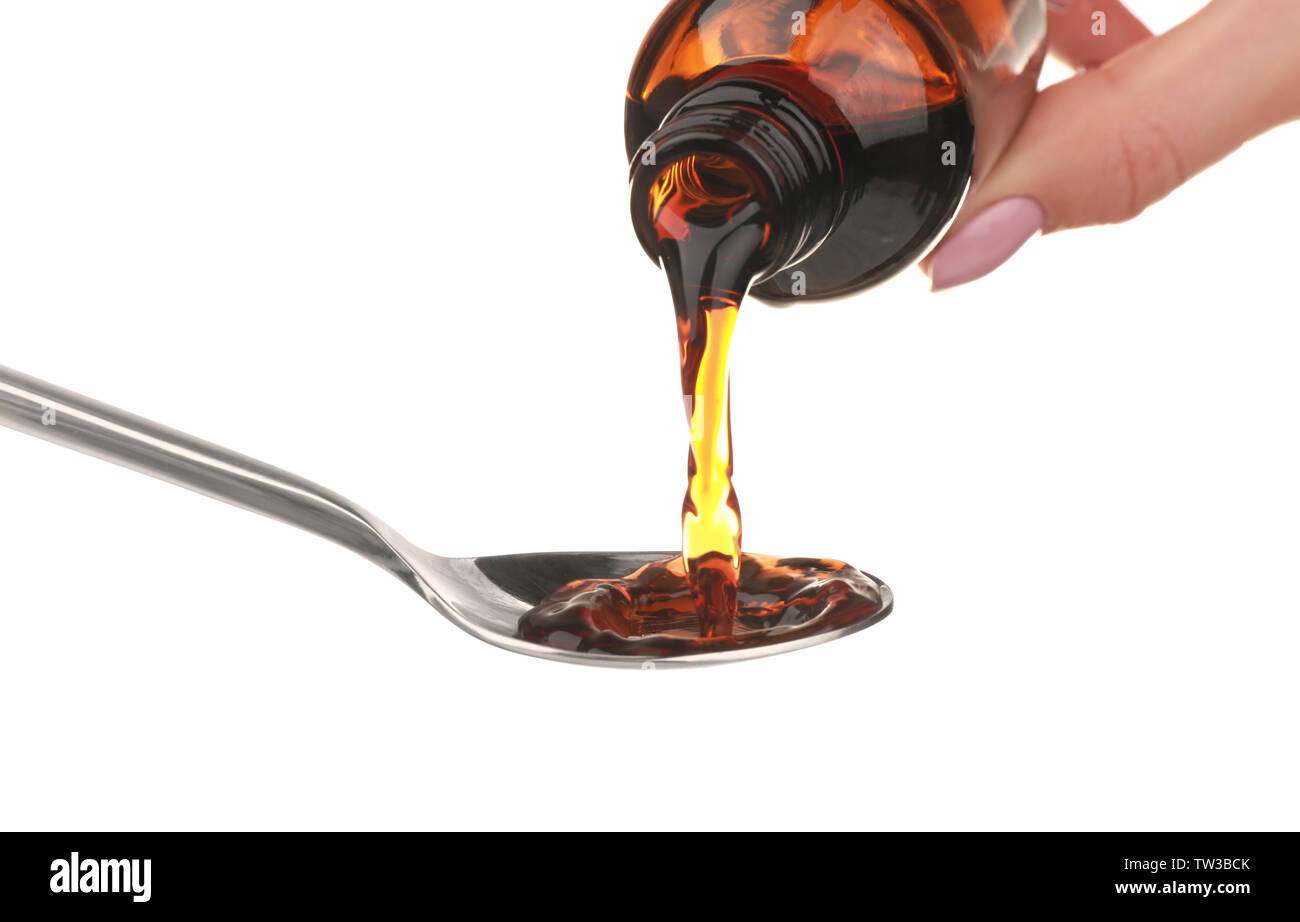 Pouring cough syrup into spoon on white background Stock Photo - Alamy