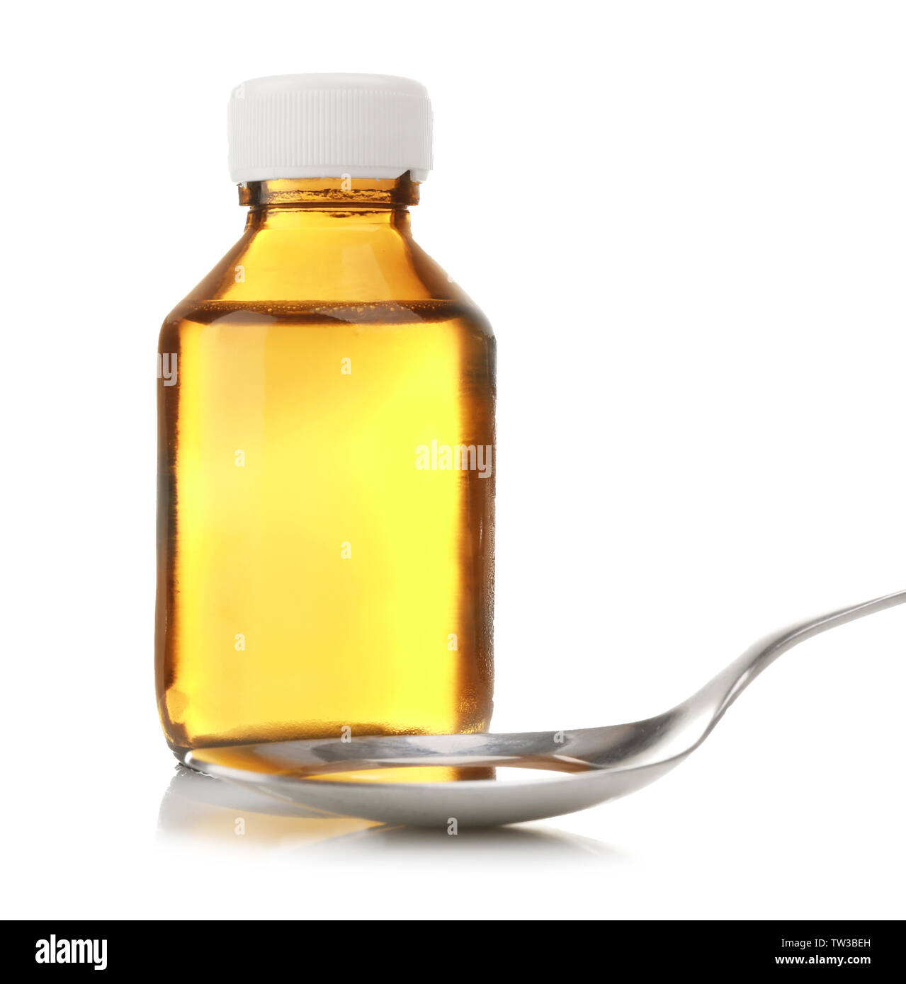 Bottle with cough syrup and poured dose in spoon on white background ...