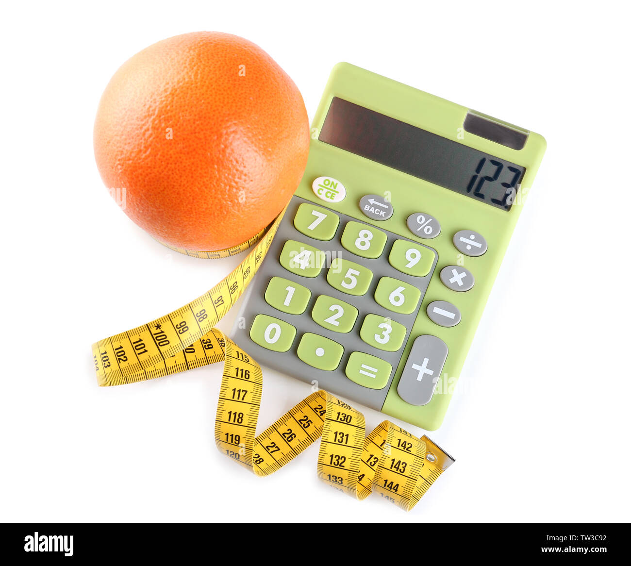 Weight loss concept. Citrus fruit, calculator and measuring tape on ...