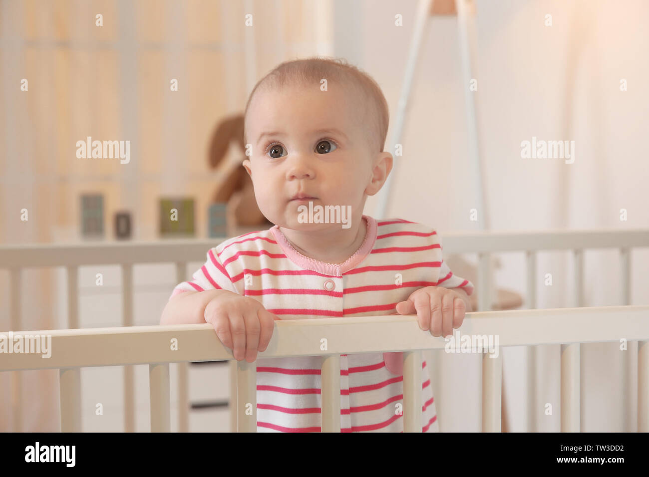 Cute little baby standing in crib at home Stock Photo - Alamy